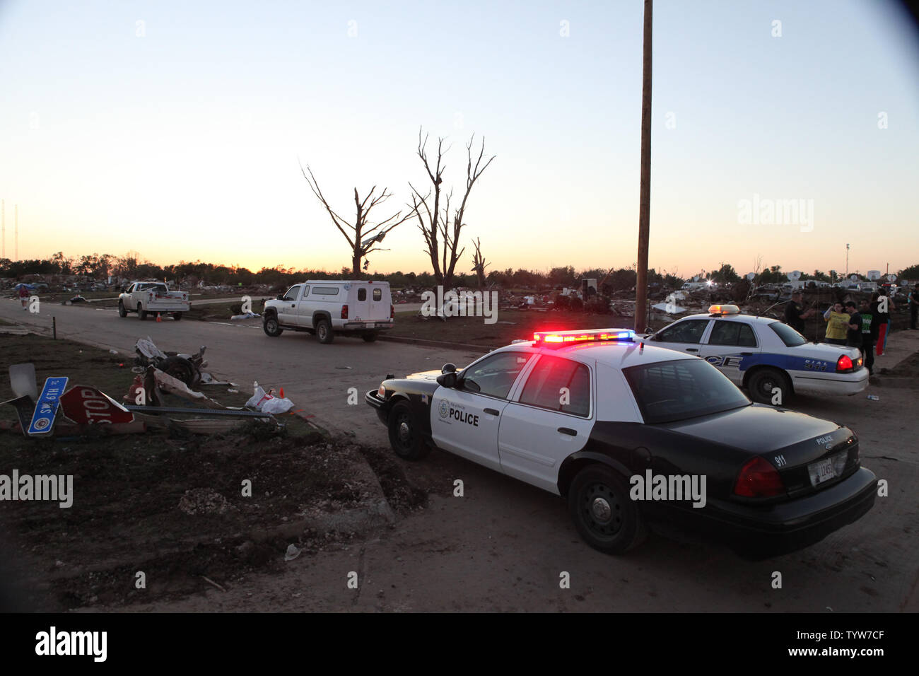 Police cars stand by as rescue workers search through debris in Moore ...