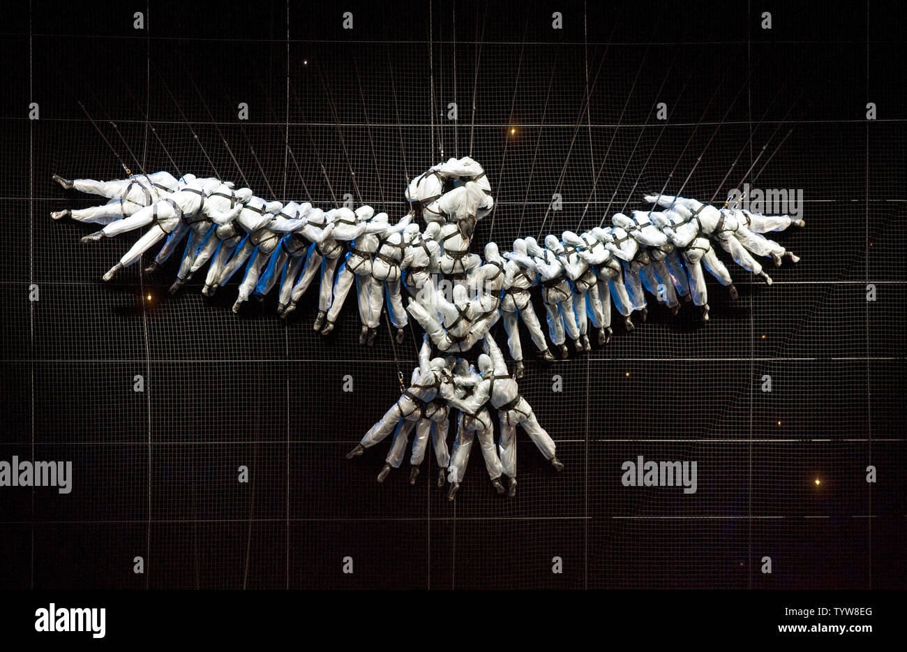 Climbers form the emblem of an eagle on a wall in the Olympic Stadium ...