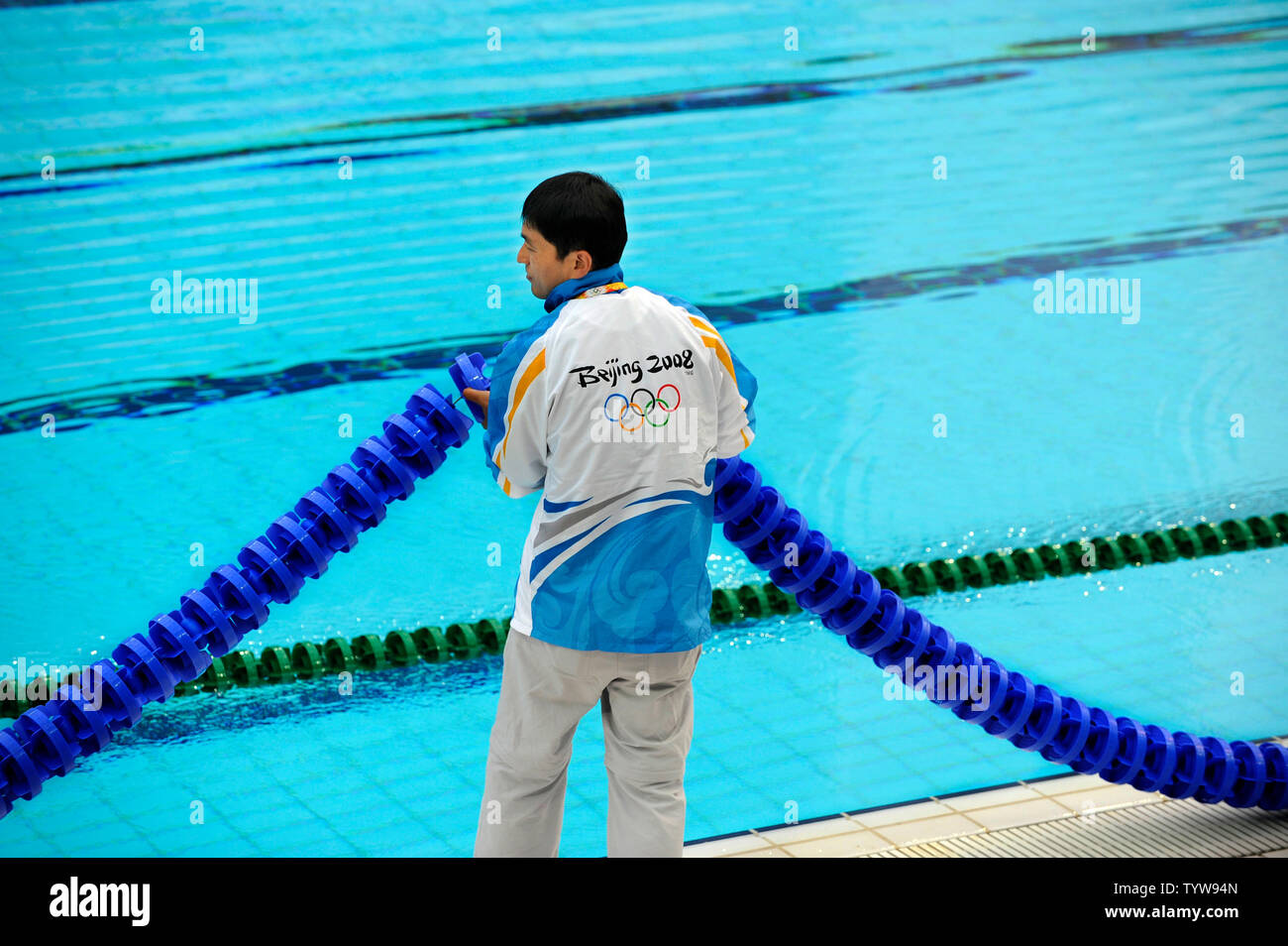 A Chinese volunteer prepares to put a lane float in the pool at the ...