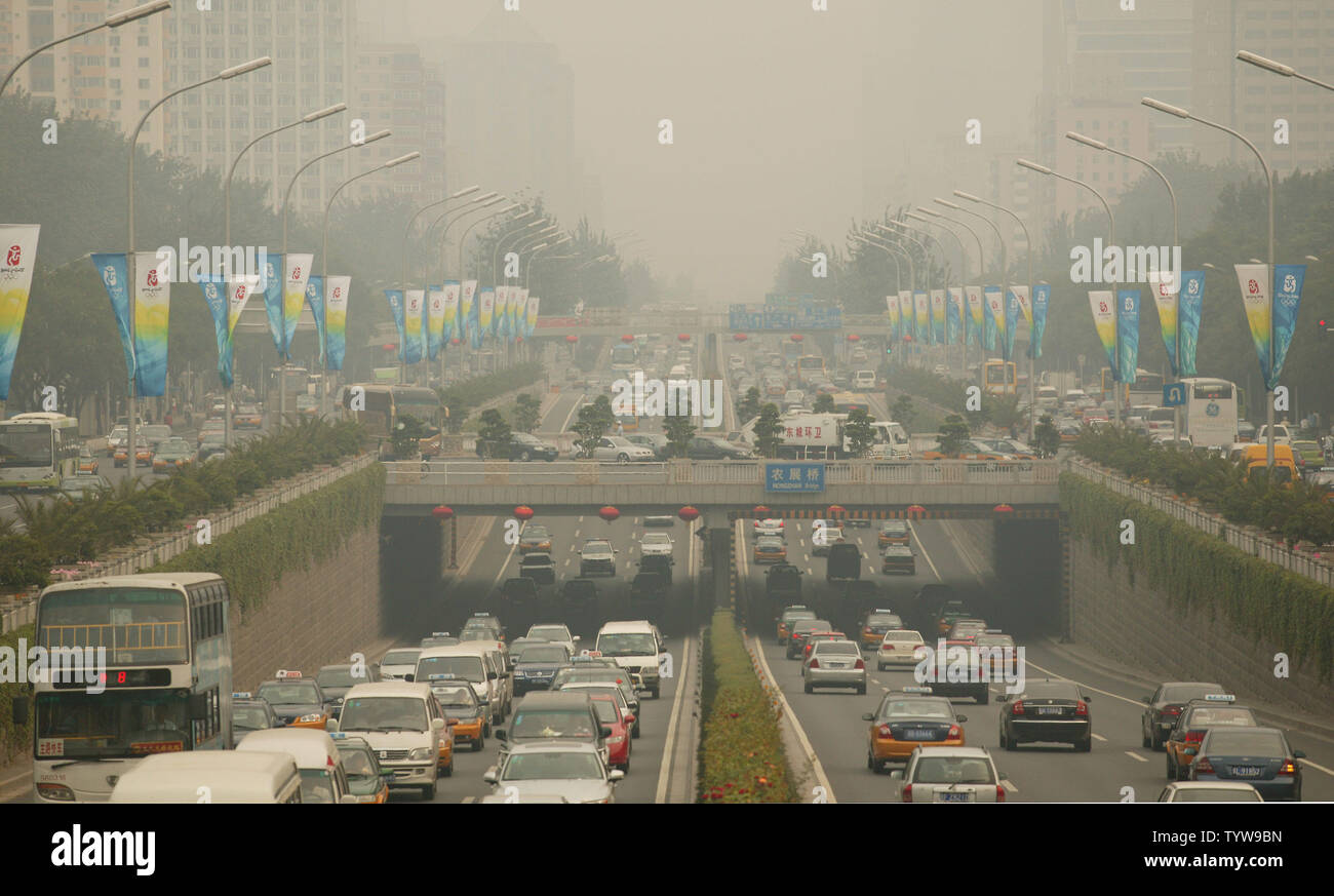 Heavy traffic slowly creeps along a major thoroughfare as dense smog ...
