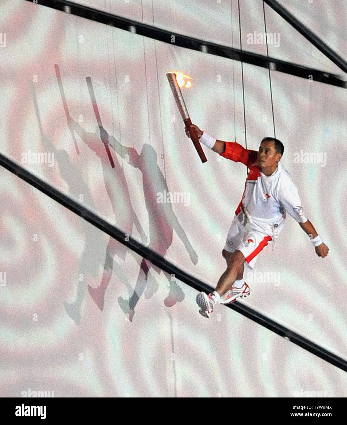 Olympic Gold Medalist Li Ning carries the Olympic Torch around the top ...