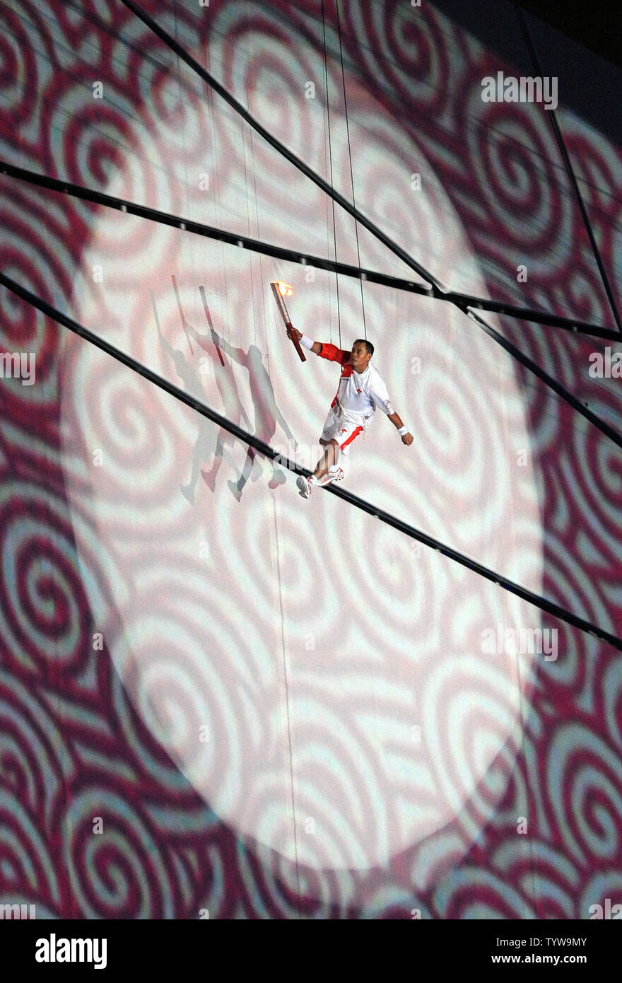 Olympic Gold Medalist Li Ning carries the Olympic Torch around the top ...