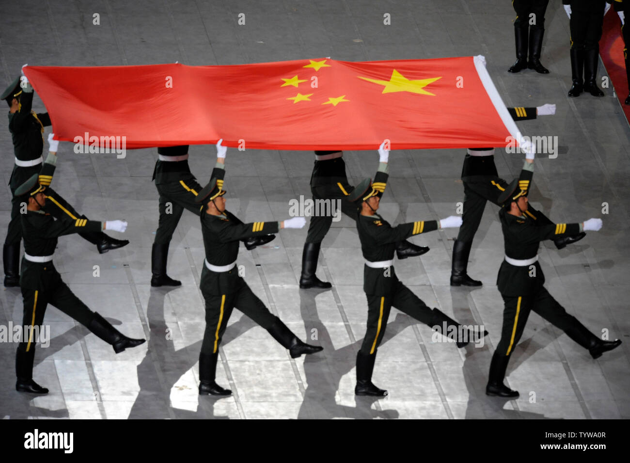 Chinese soldiers carry the national flag to be raised on a flagpole at ...