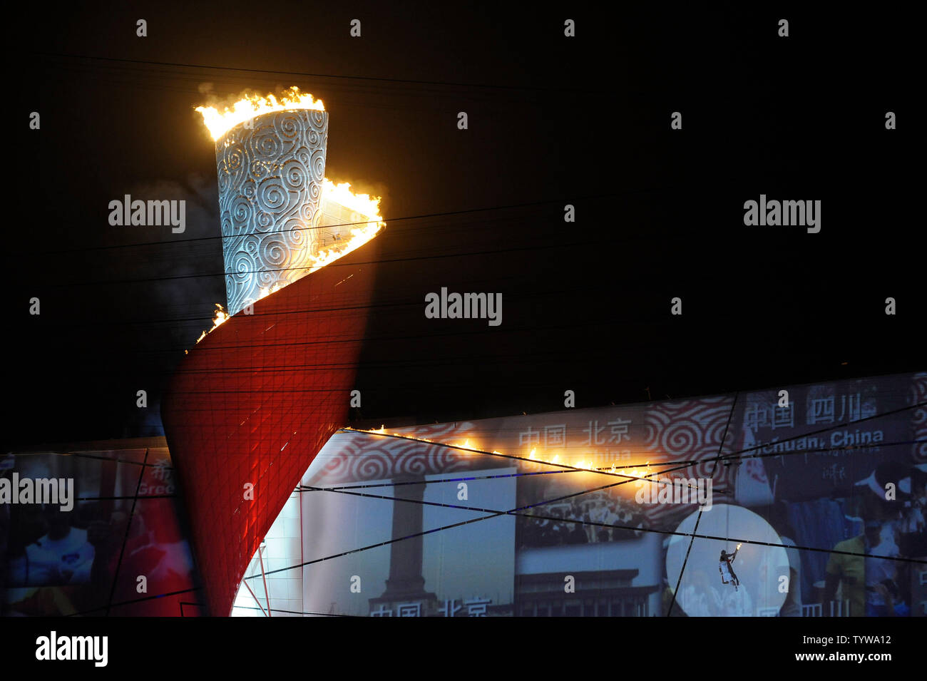 Former Chinese gold medal winner Li Ning (R) lights the Olympic Flame ...