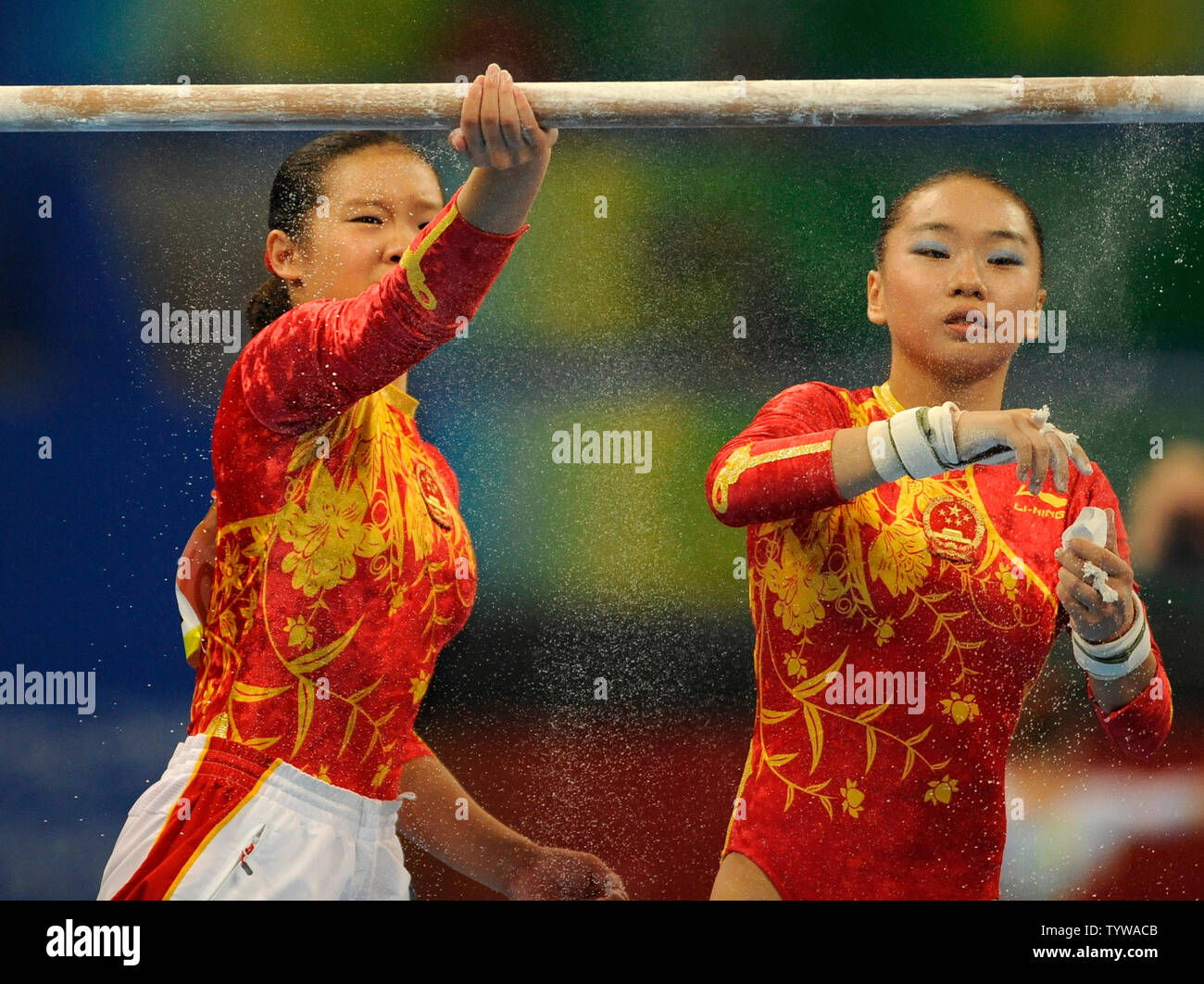 Chinese gymnasts Cheng Fei (L) and Li Shanshan apply chaulk to the ...