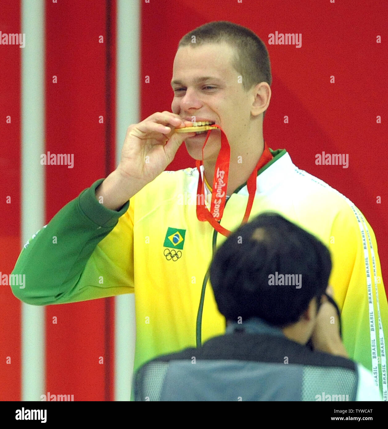 Brazilian Cesar Cielo Filho bites the gold meda he won with an Olympic ...