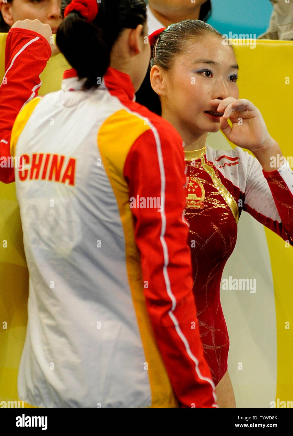 Chinese gymnast Li Shanshan (R) has tears in her eyes as she talks to ...