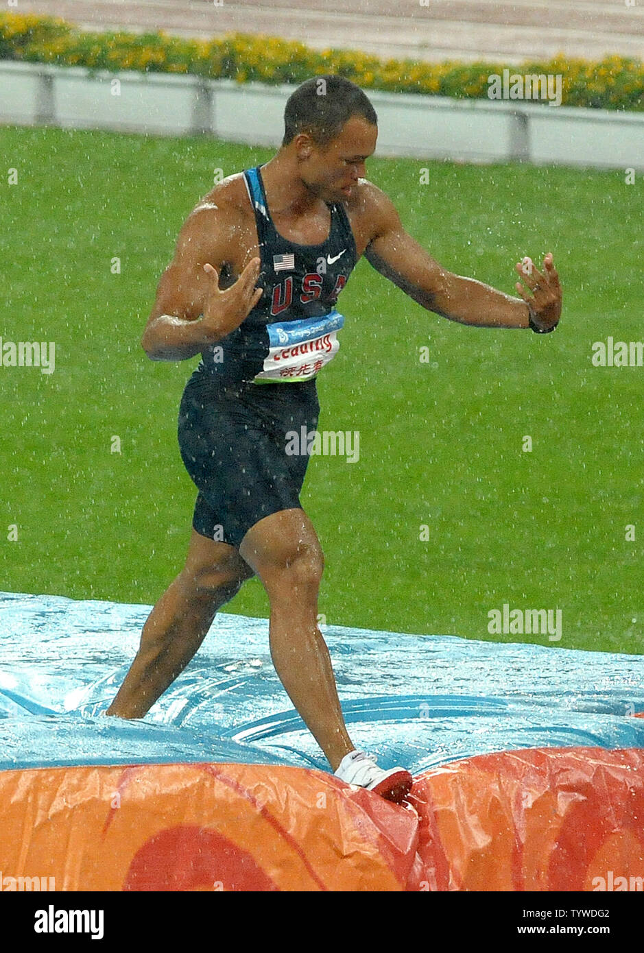 USA's Bryan Clay tries to shake water from his arms after missing a ...