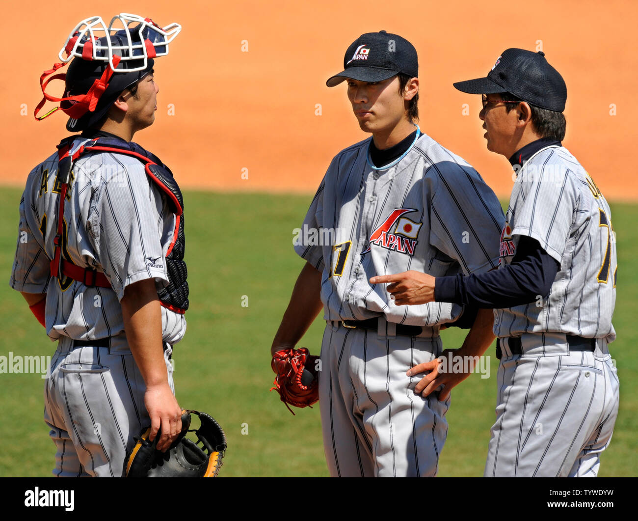 Japan's pitching coach Yutaka Ono (R) confers with his picher Tsuyoshi ...