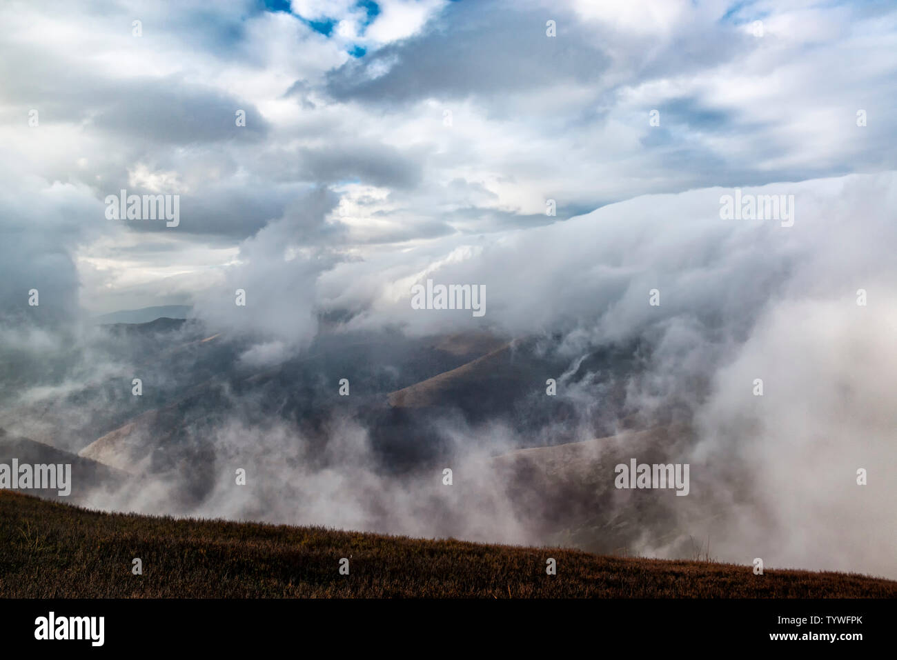 Dramatic rainy alpine landscape with rain clouds below the mountain ...