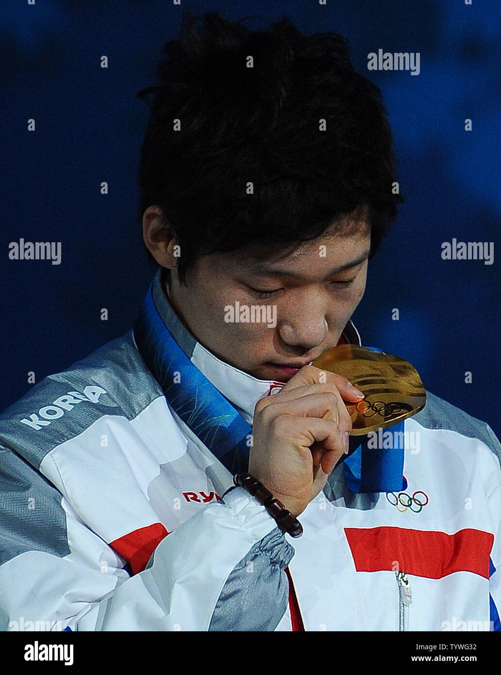 Tae-Bum Mo of Korea takes a close look at the gold medal he earned for ...