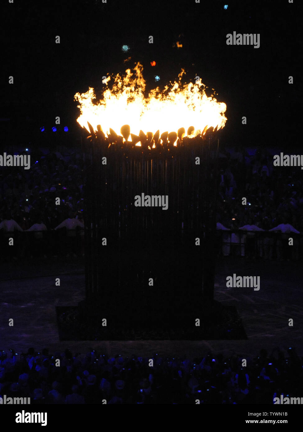 The olympic torch is lit during the ceremony hi-res stock photography ...