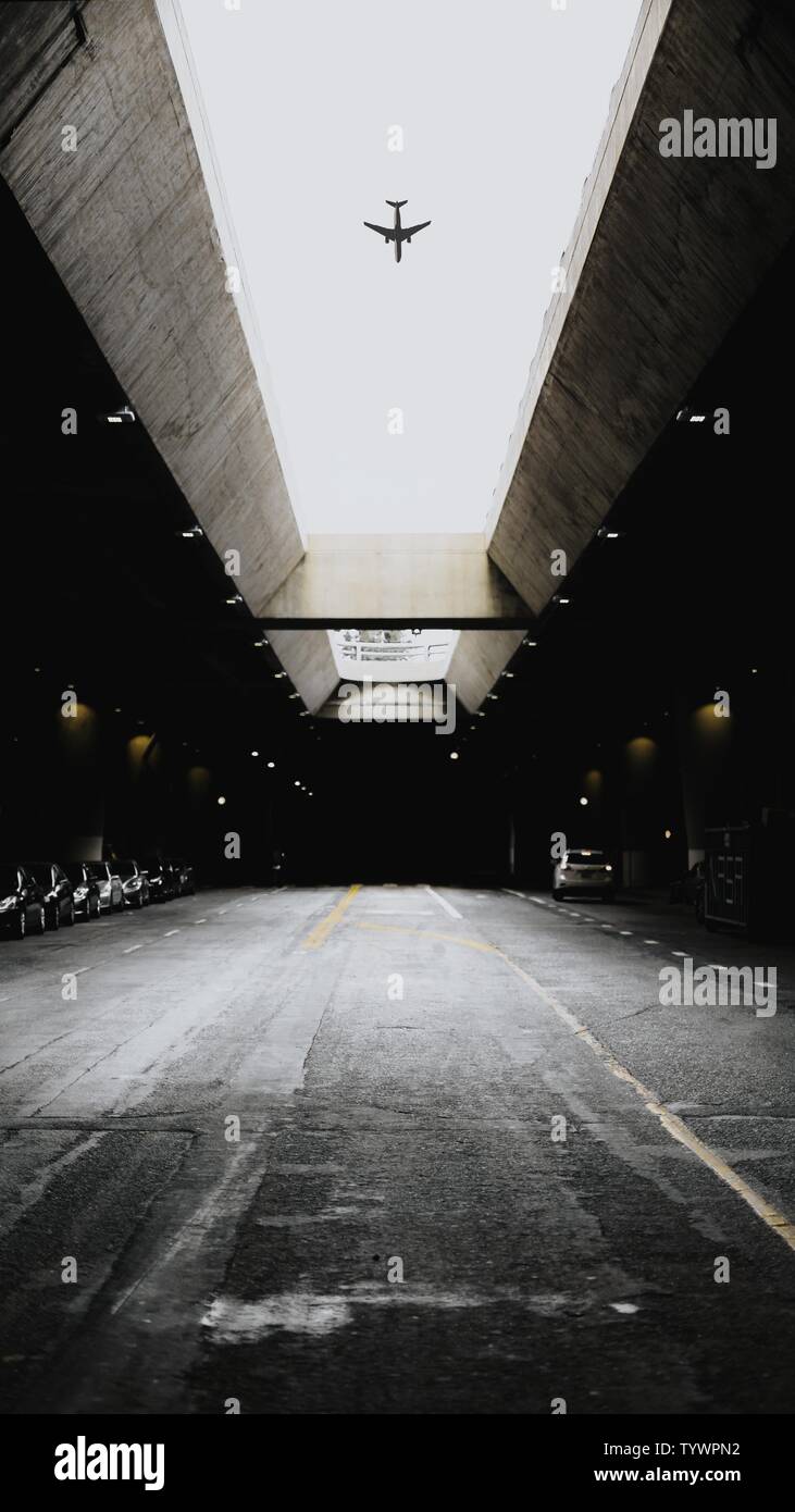 Vertical shot of an airplane flying in the clear white sky shot from ...