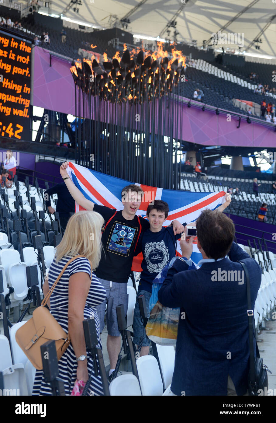 Spectators take pictures while cauldron with the Olympic flame burns at ...
