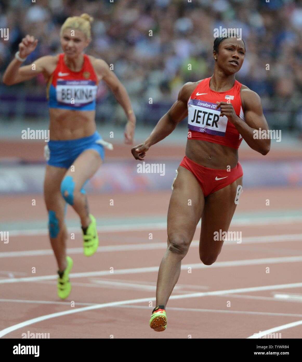 Carmelita Jeter of the USA (R) crosses the finish line in heats for the ...