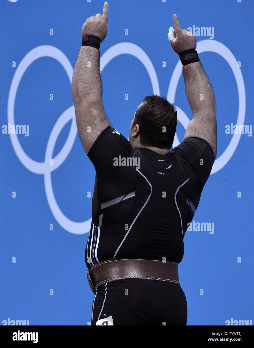 Iranian weightlifter Behdad Salimkordasiabi lifts his arms in ...