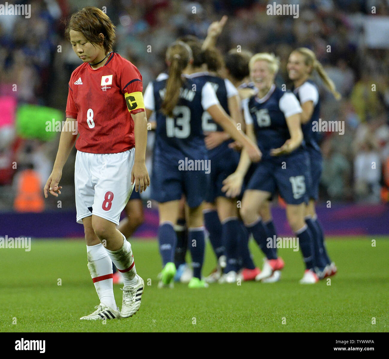 Japan's midfielder Aya Miyama (L) walks off the pitch in dejection as ...