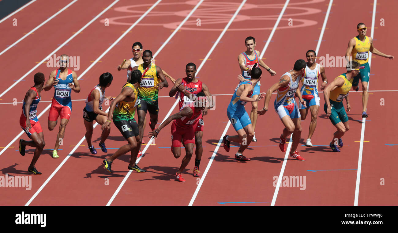 Athletes line up to receive their batons in the third leg of the Men's ...