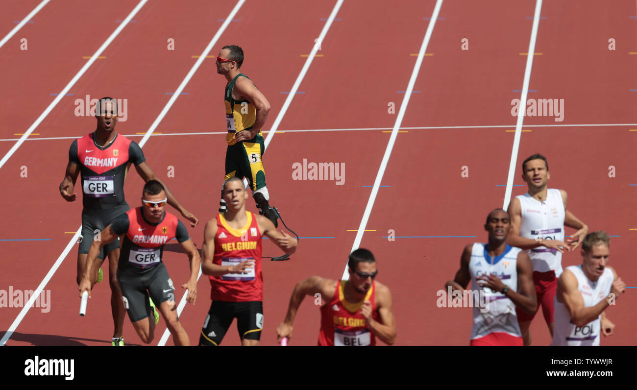 South Africa's Oscar Pistorius walks off the track after his teammate Ofentse Mogawane crashes ...