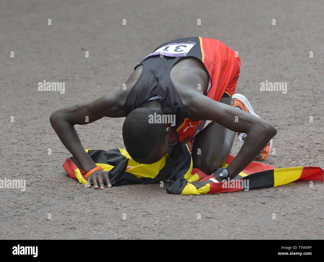 Stephen Kiprotich of Uganda kisses the ground after crossing the finish ...