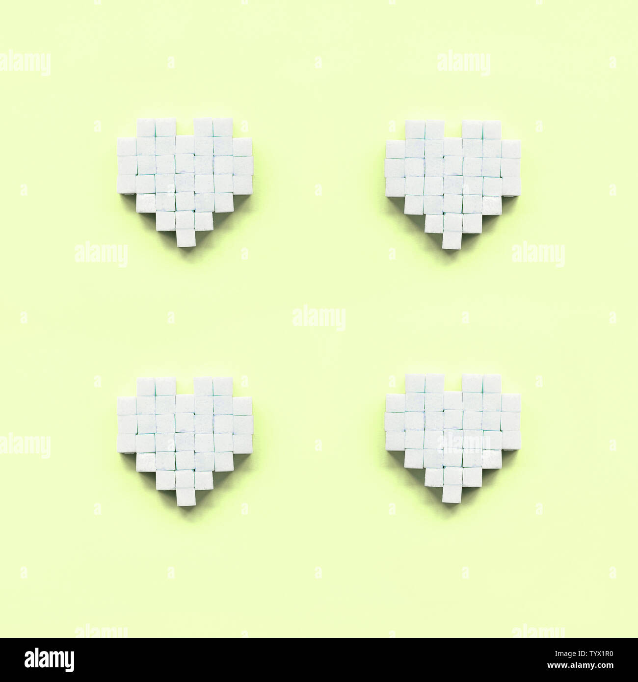 A few hearts made of sugar cubes lies on a trendy pastel lime ...
