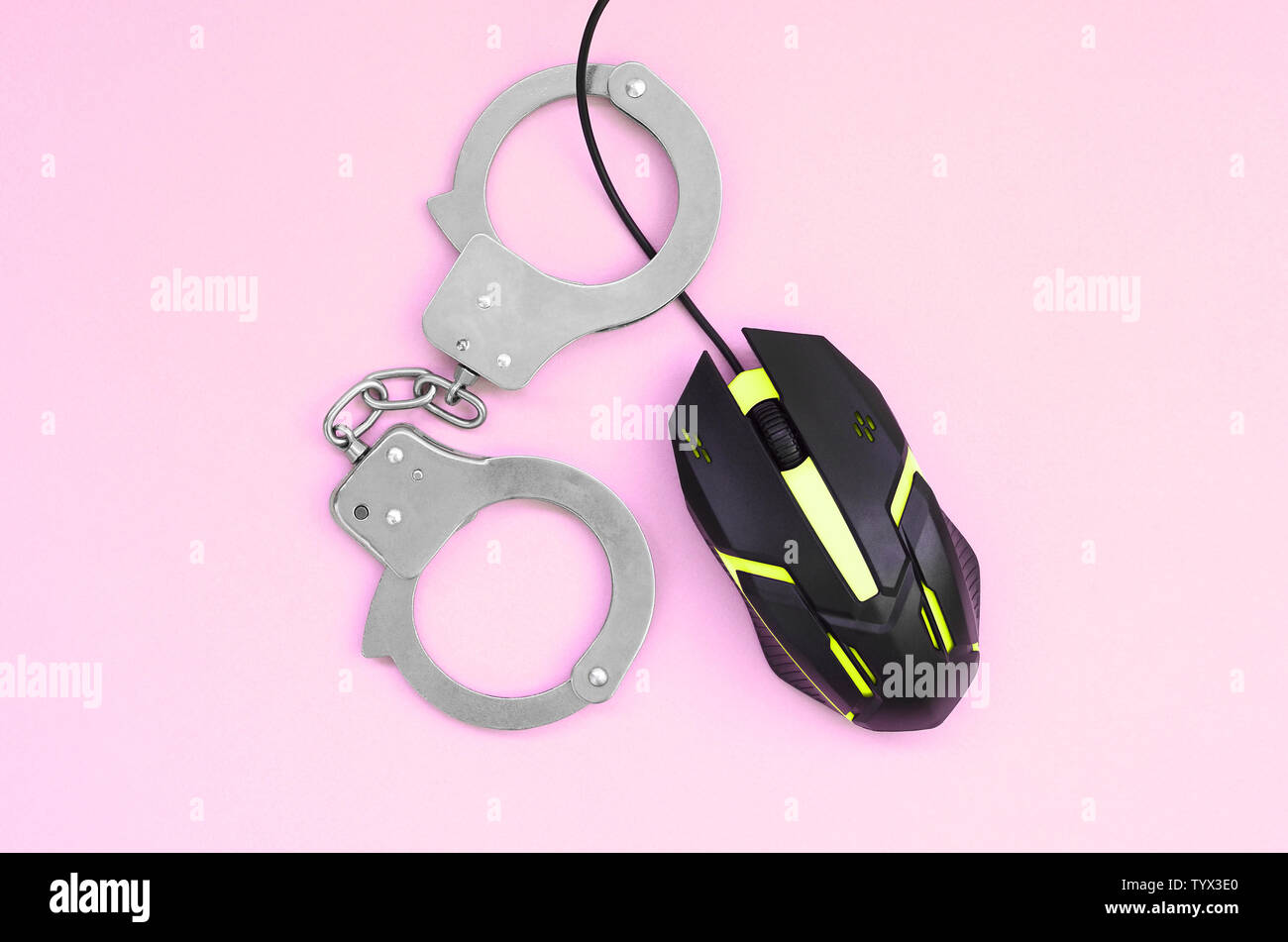 Computer mouse in a yellow color is chained in handcuffs on the ...