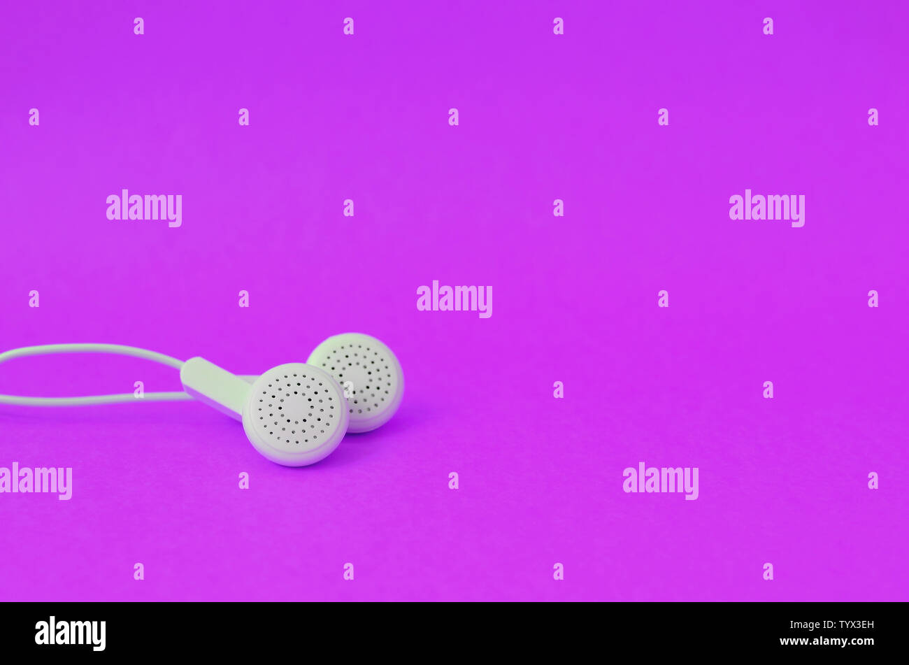 White modern headphones lie on a bright purple background. A template ... White modern headphones lie on a bright purple background. A template ...