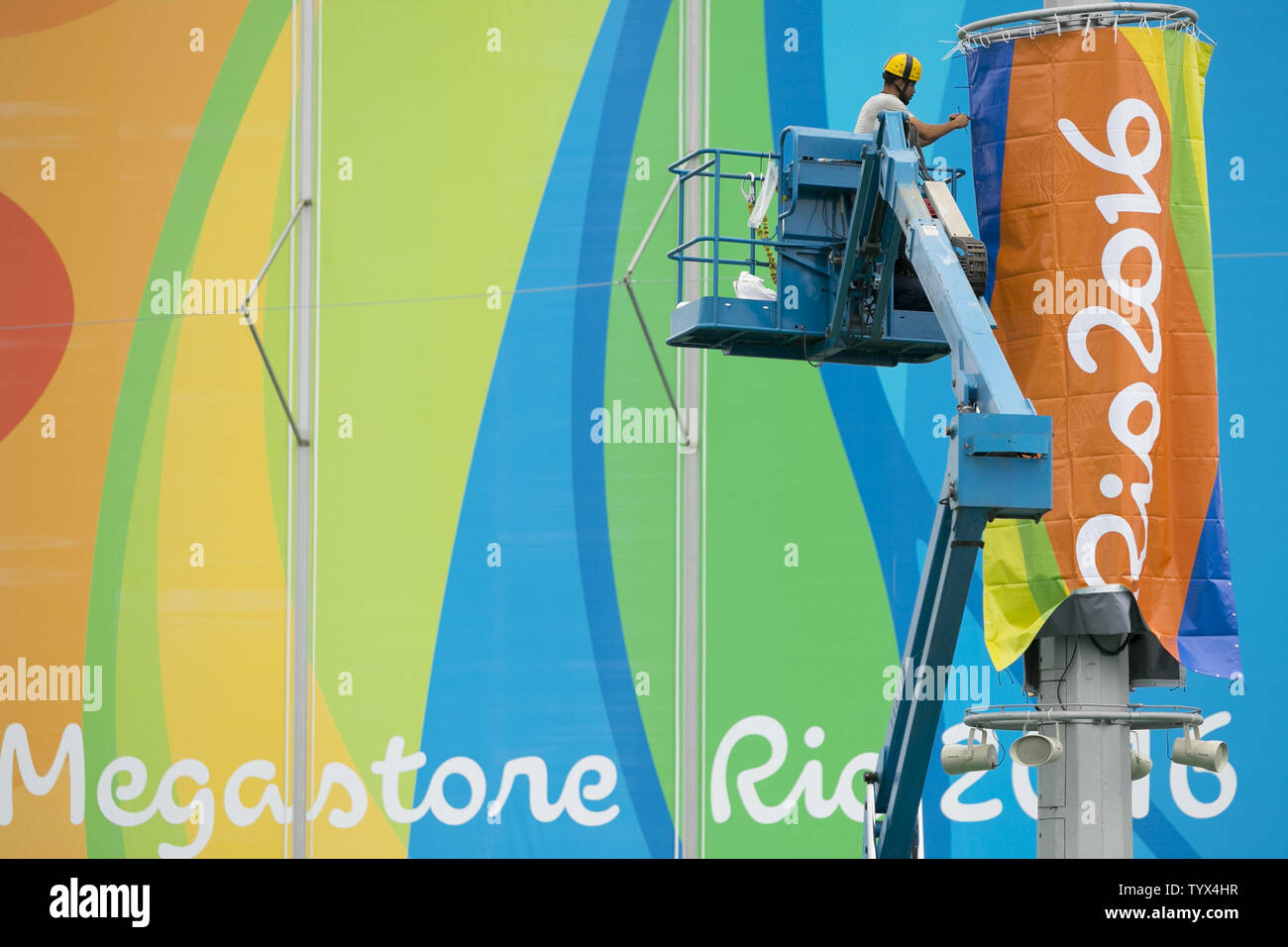 Workers hang banners in front of an official Olympic merchandise store ...