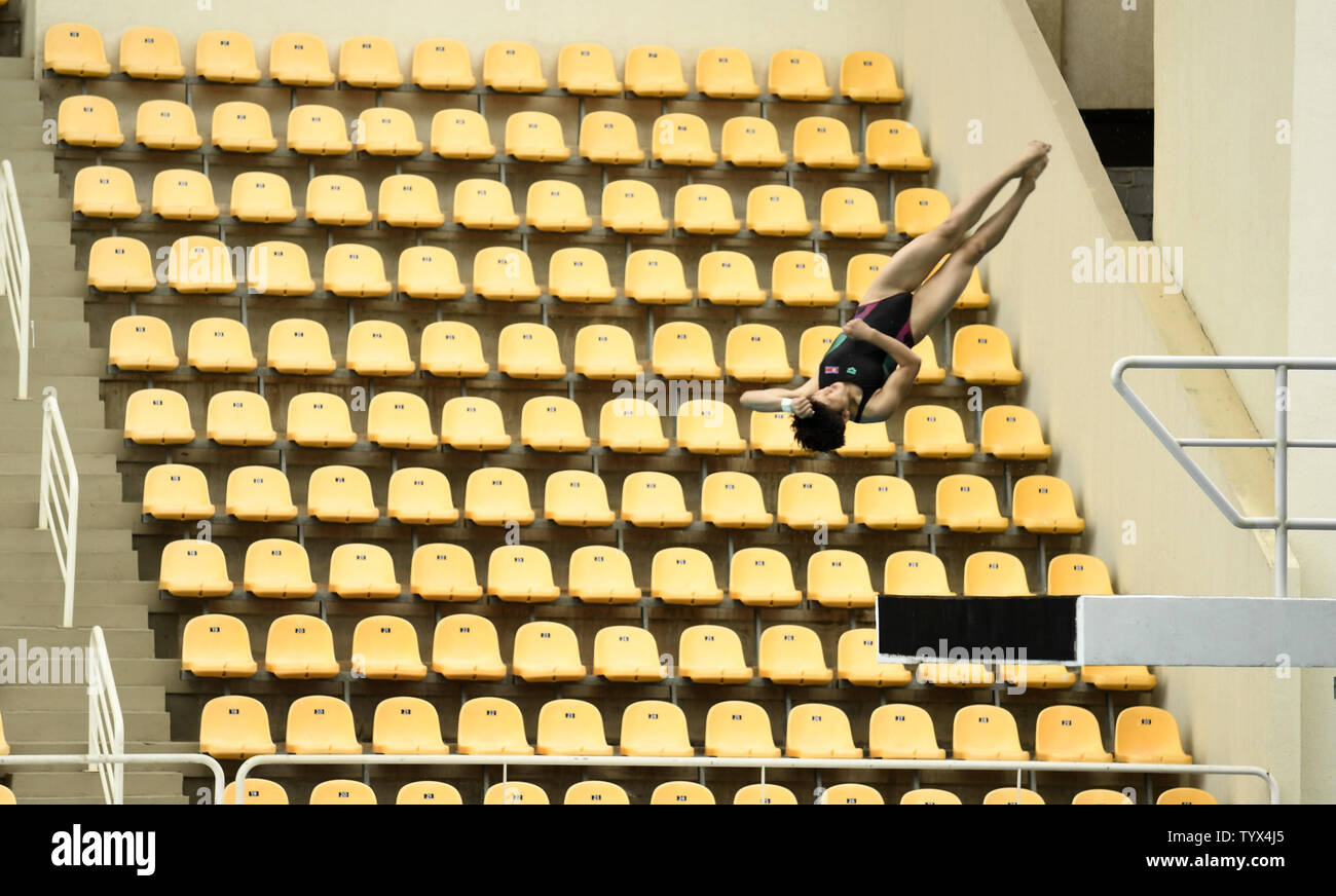 A platform diver makes a practice dive before empty seats at the venue ...