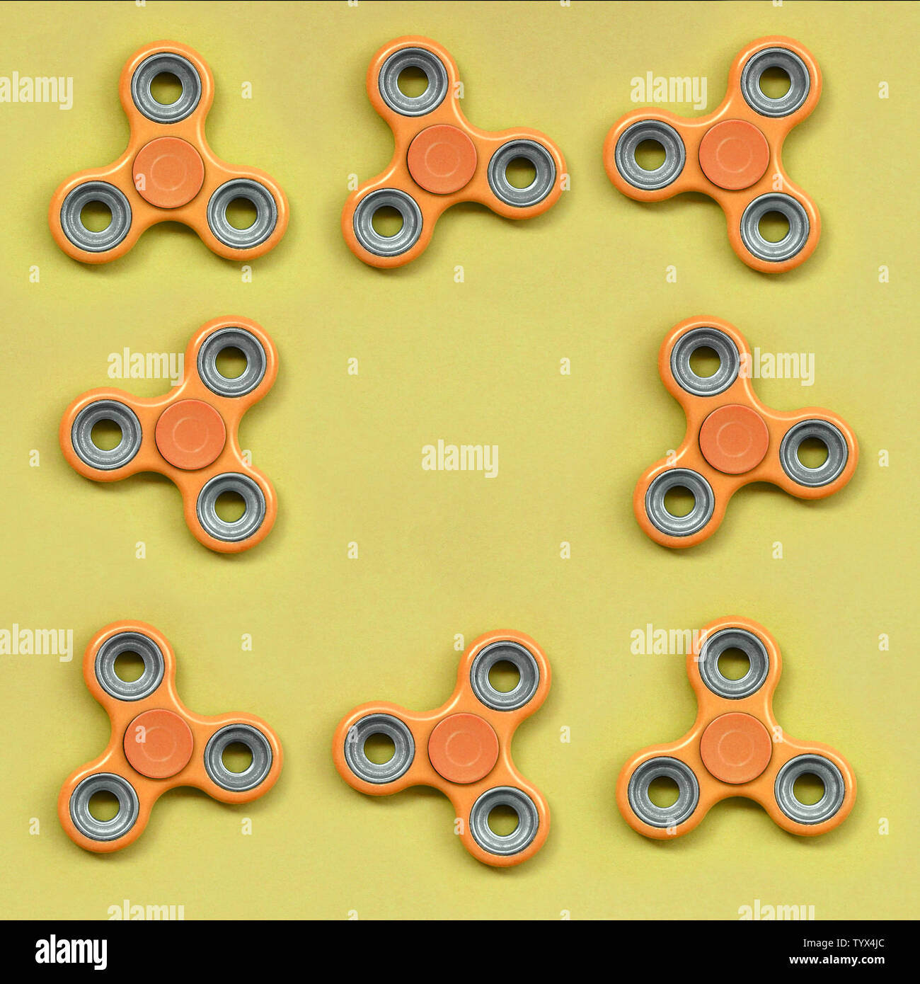 Many orange fidget spinners lies on texture background of fashion ...