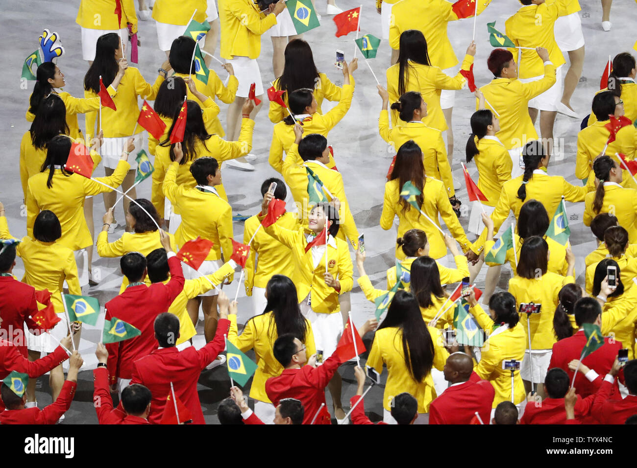 Members of the Chinese Olympic team (women in yellow, men in red) enter ...