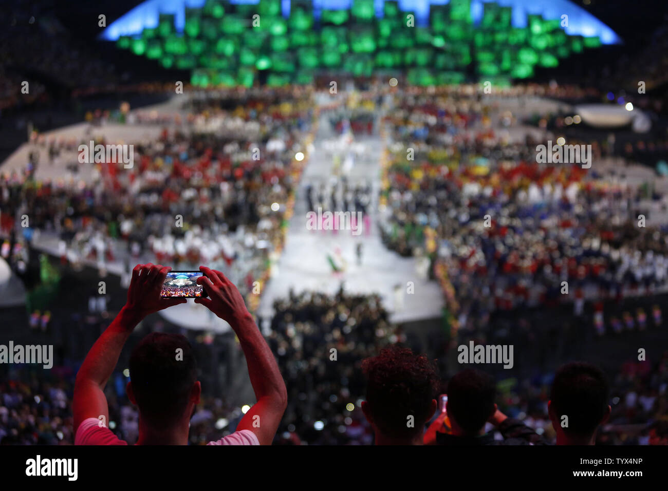 A spectator takes a picture with his smartphone of the athletes from ...
