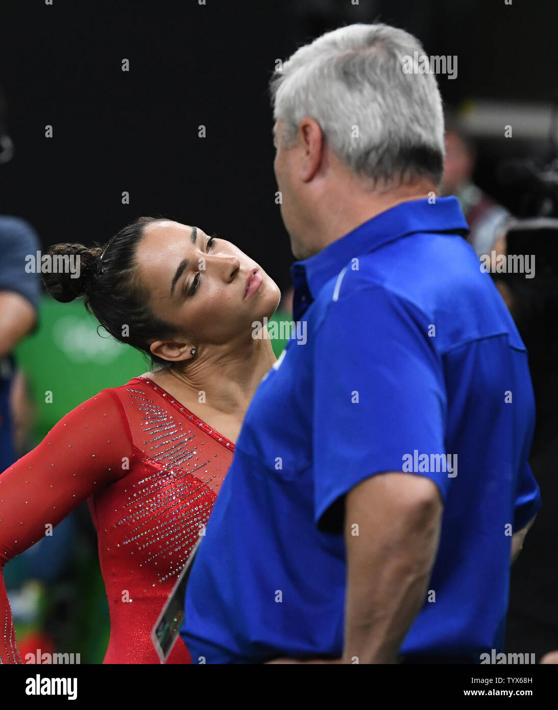 Aly Raisman of the United States stretches near coach Mihai Brestyan ...