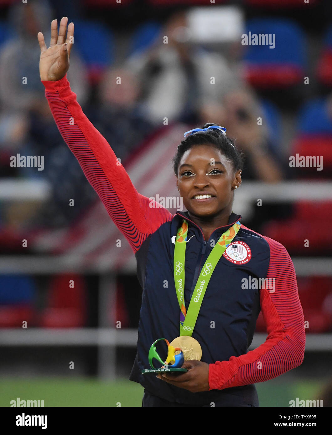Simone Biles waves holding her gold medal after competeing at the Women ...