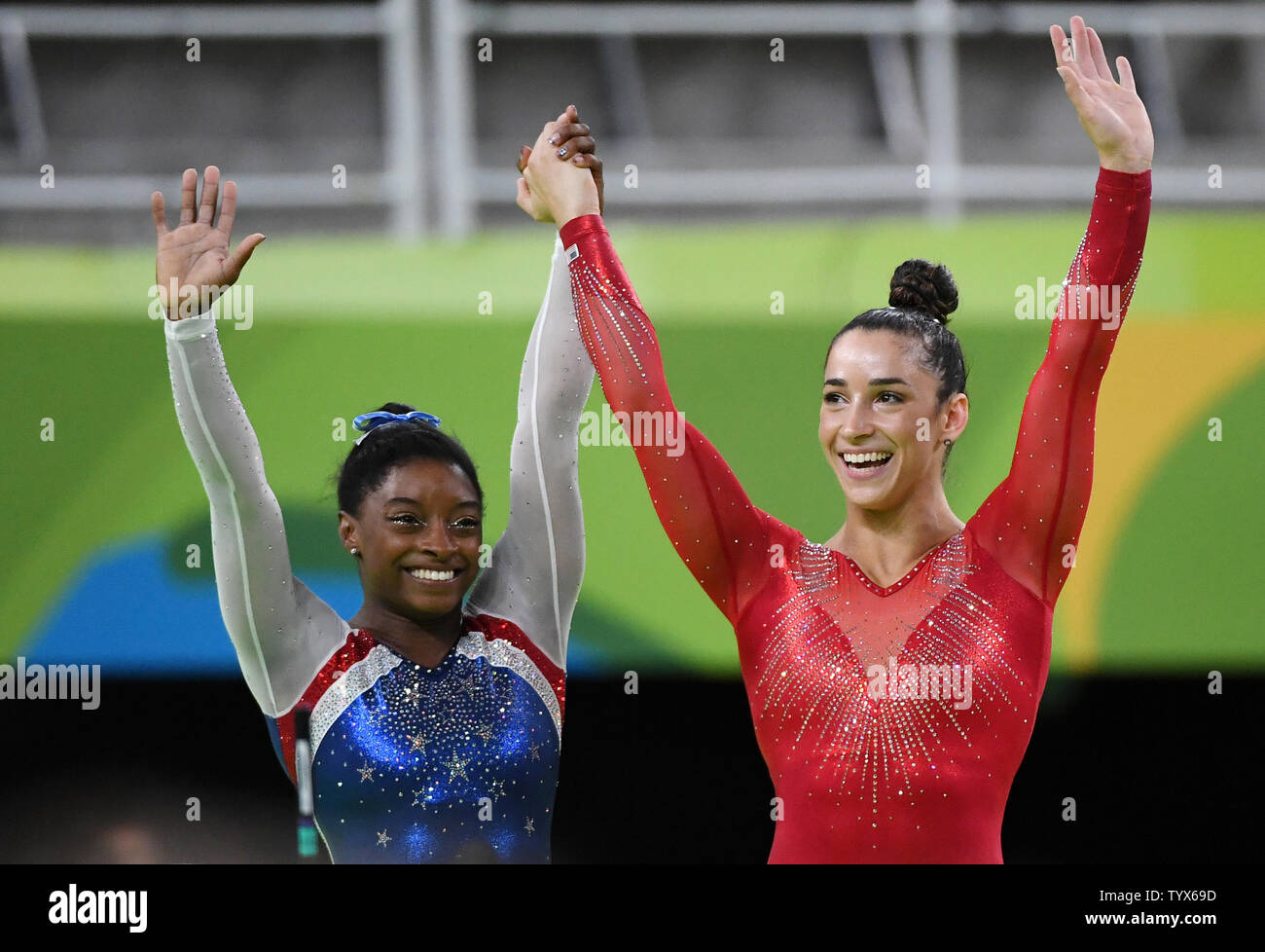 Aly Raisman and Simone Biles of the United States raise their hands ...