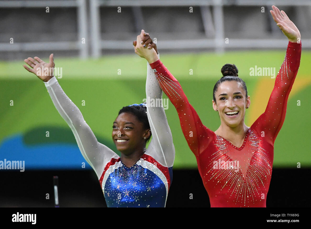 Aly Raisman and Simone Biles of the United States raise their hands ...