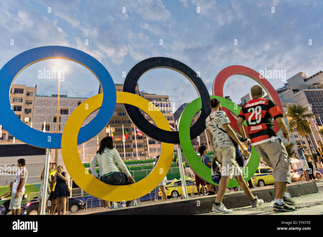 Local residents walk past the Olympic Rings on Copacabana beach at ...