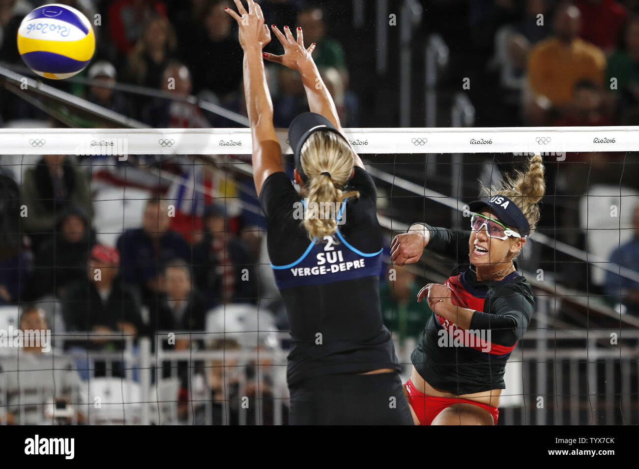 USA's Aril Ross (R) spikes the ball past Switzerland's Anouk Verge ...