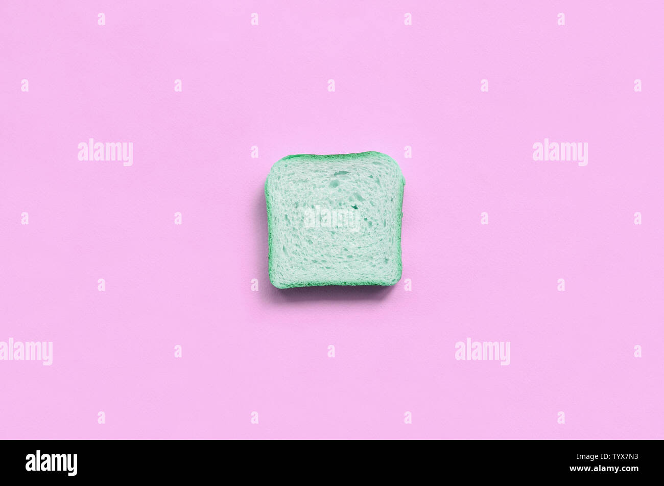 A piece of green bread lies on texture background of fashion pastel ...