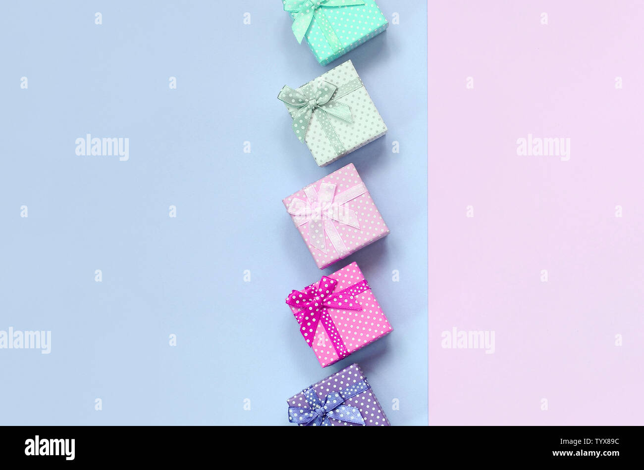 Small gift boxes of different colors with ribbons lies on a violet and ...