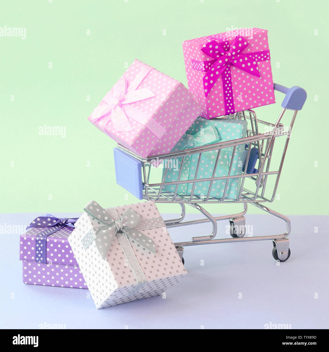 Small gift boxes of different colors with ribbons lies in shopping cart ...