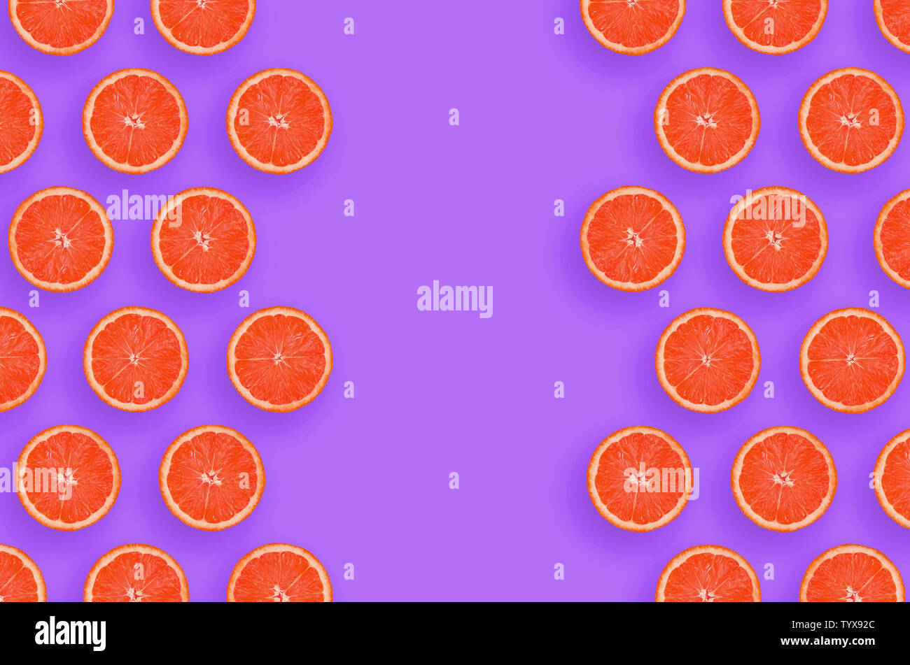 Top view of grapefruit slices on bright purple background. A saturated ...
