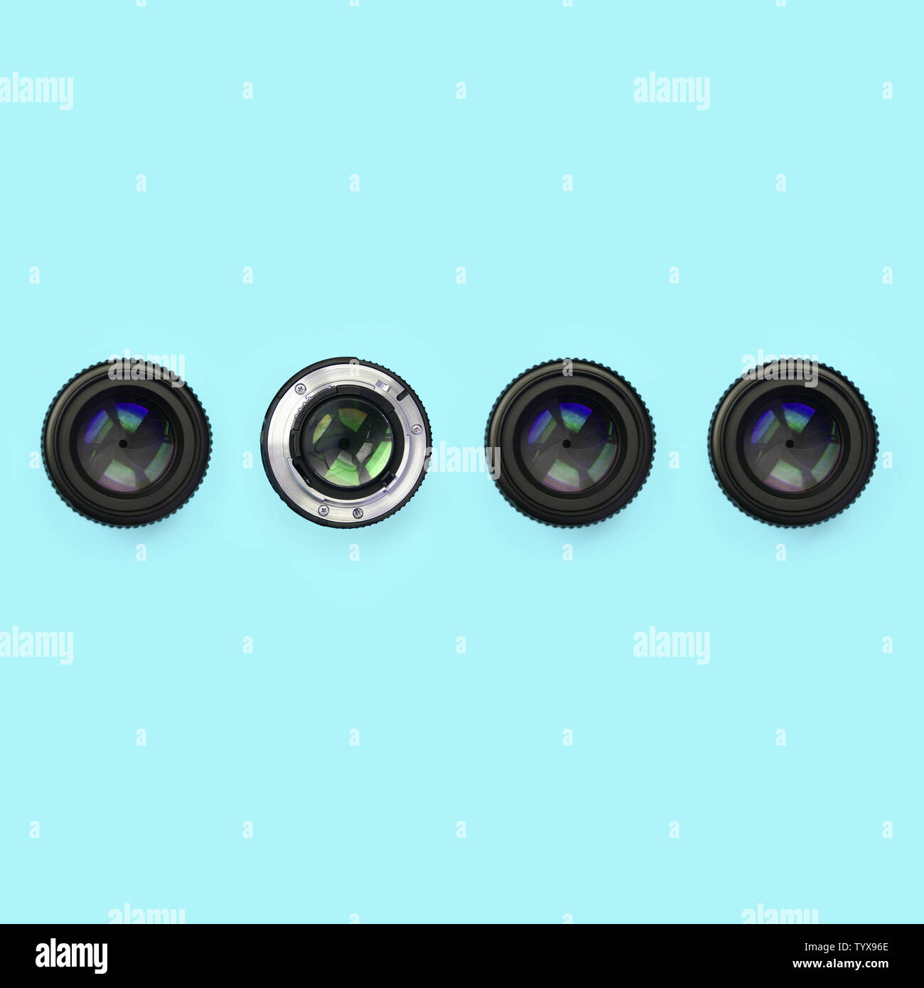 A few camera lenses with a closed aperture lie on texture background of ...