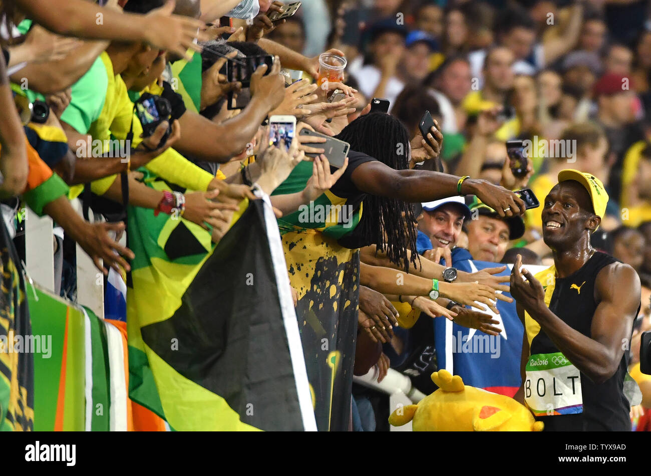 Gold medal winner Jamaica's Usain Bolt greets track fans reaching out ...