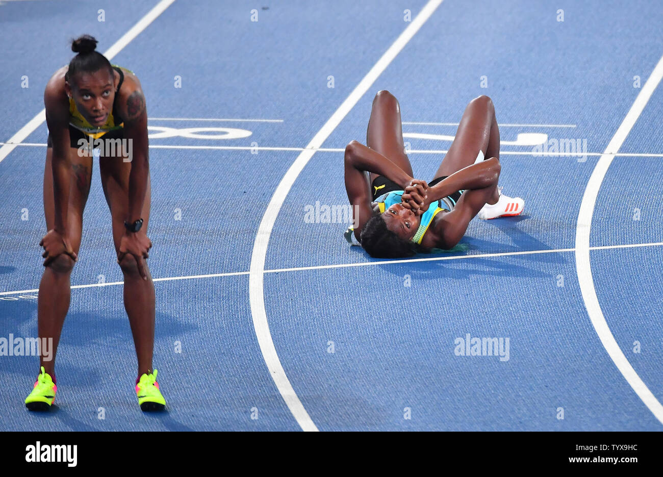 Shaunae Miller (BAH) falls down after diving to win the Women's 400m as ...