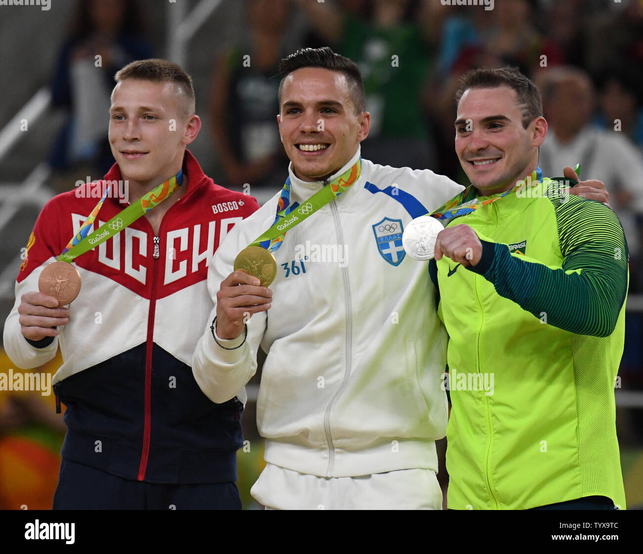 Greece's Eleftherios Petrounias (C) displays his Gold Medal along with ...