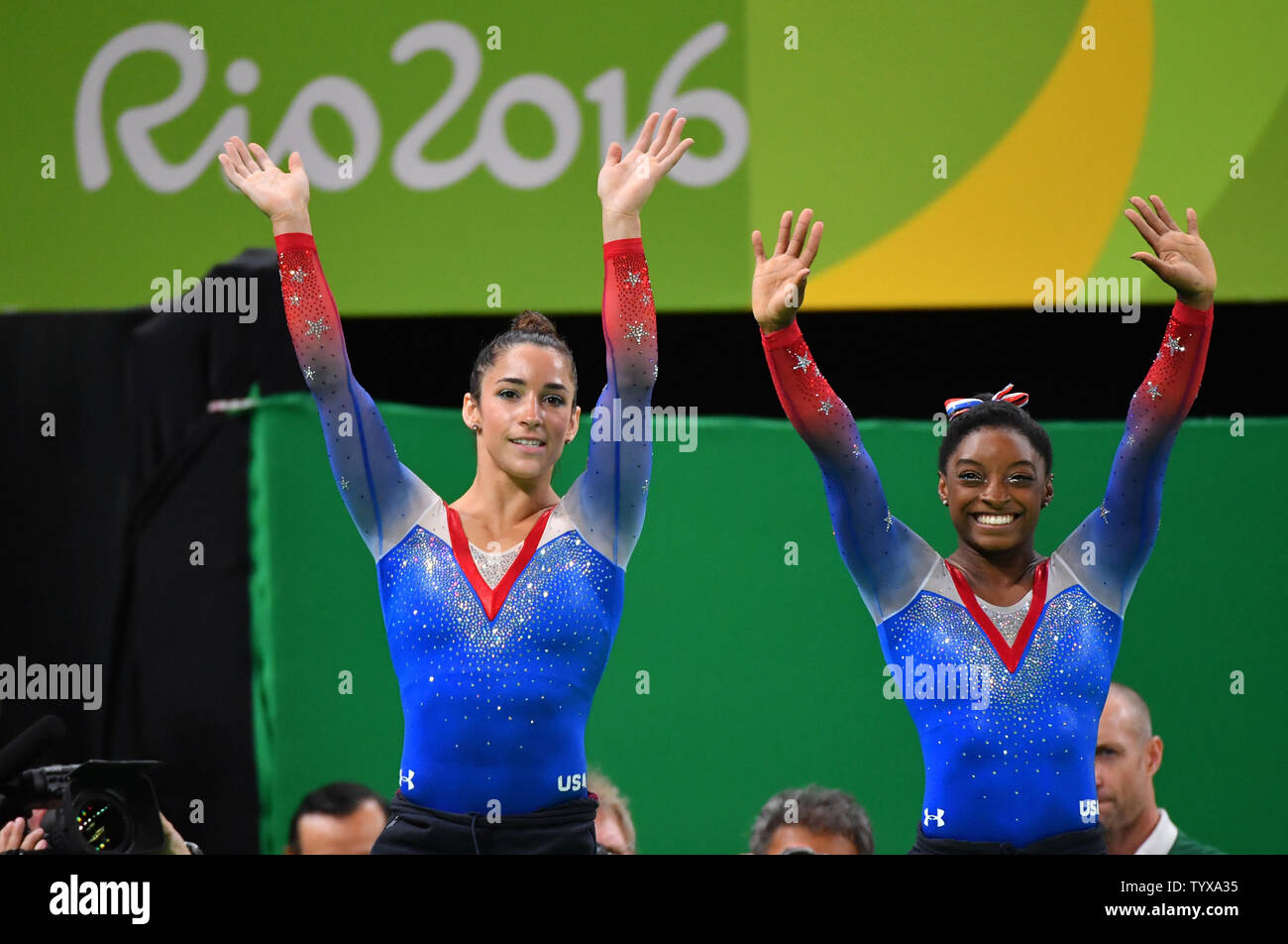 Aly Raisman and Simone Biles of the United States raise their hands ...