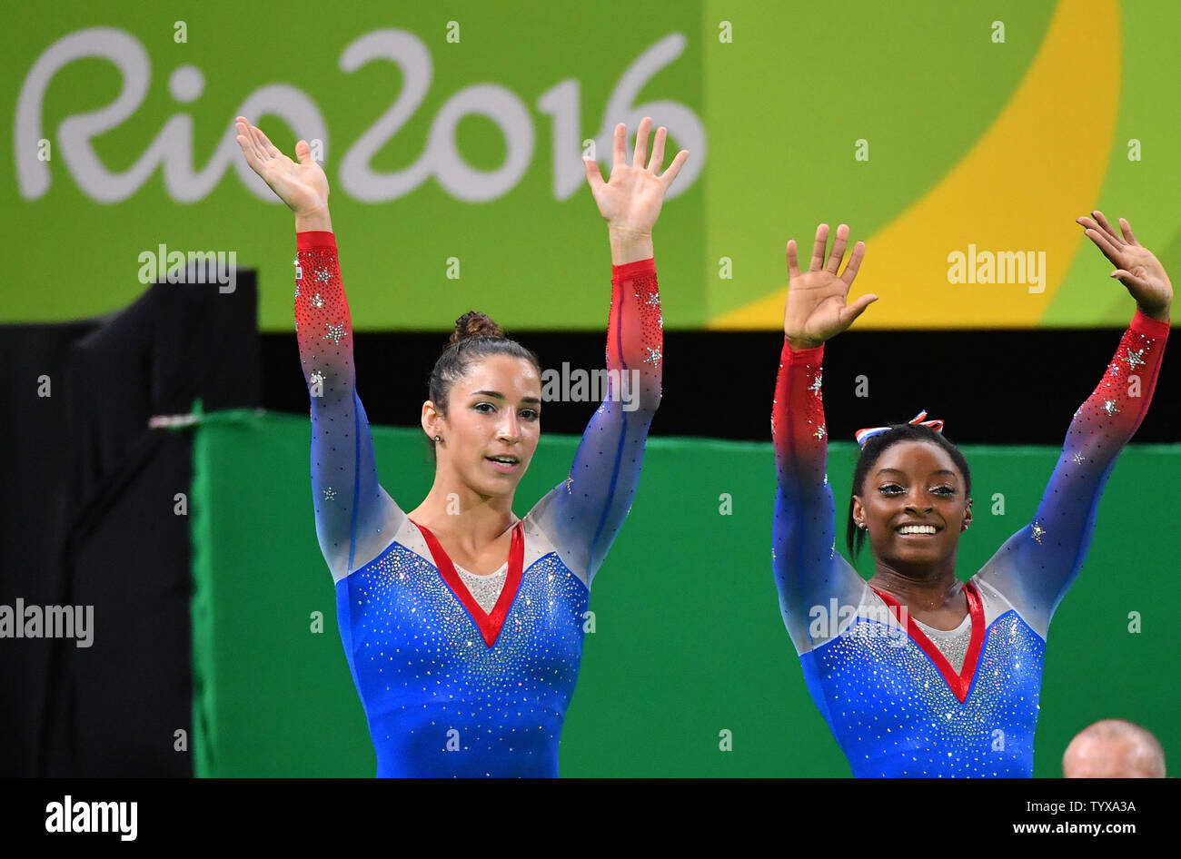 Aly Raisman and Simone Biles of the United States raise their hands ...