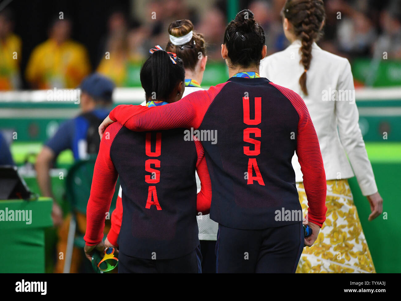 Aly Raisman puts her arm around Simone Biles of the United States after ...