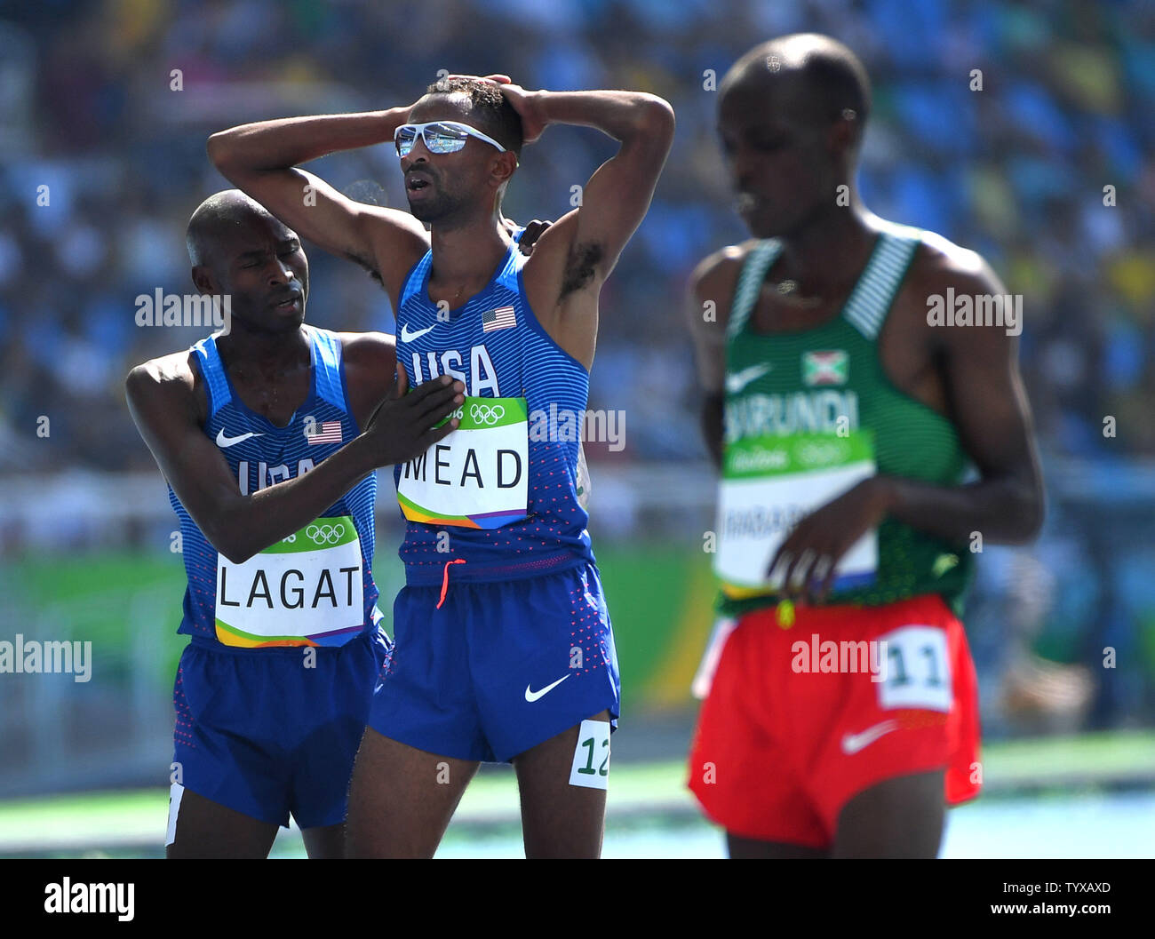 Bernard Lagat and Hassan Mead both of the United States help each other ...